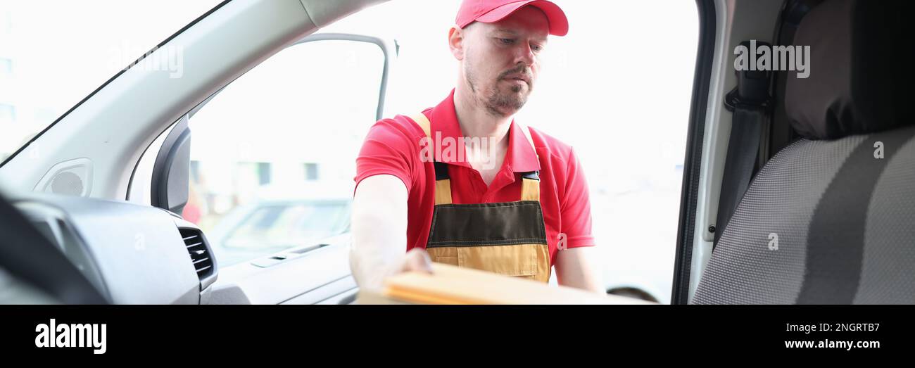 Young delivery man is loading boxes into car Stock Photo - Alamy