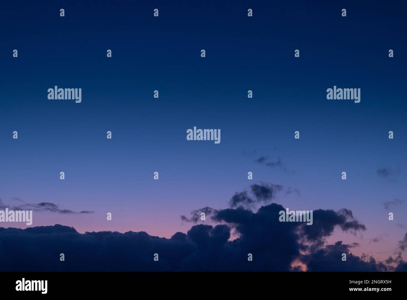 The tranquil beauty of a small crescent moon suspended in a sea of blue ...