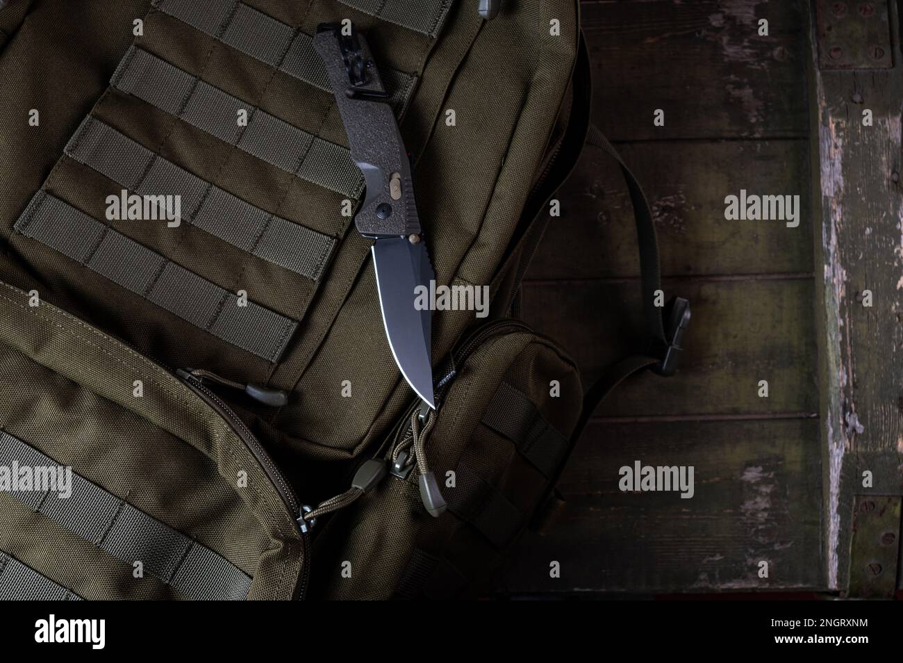 Folding sharp army knife on a military backpack. Knife with clip and ...