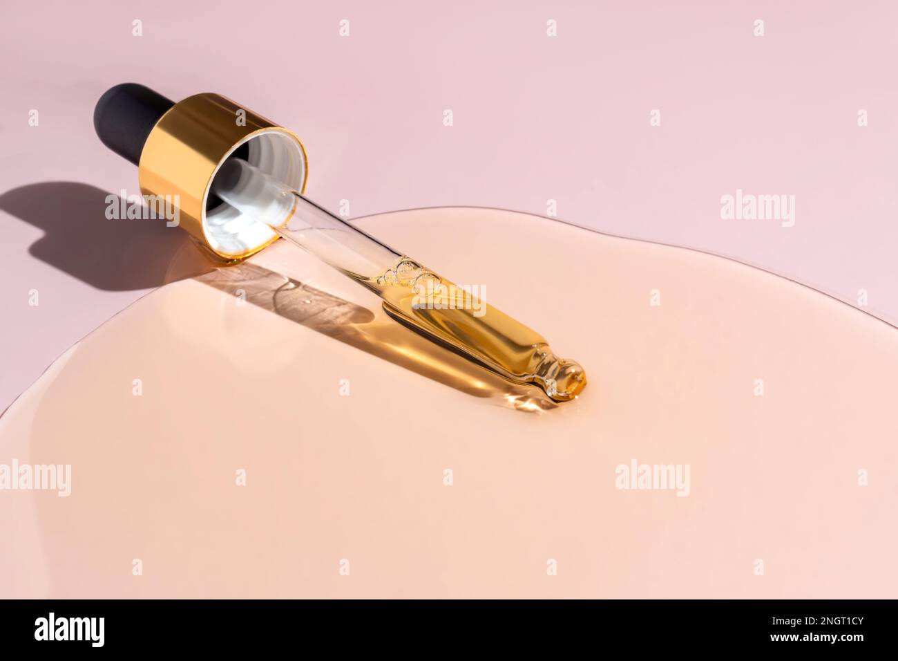 Yellow texture of a drop of whey or olive oil on a pink background ...