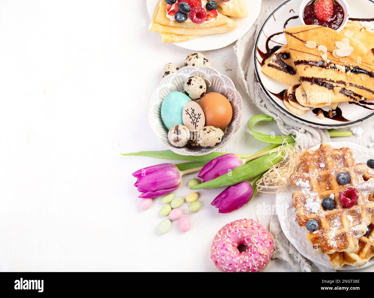 Easter sweet dessert table. Pancakes, crepes, waffles and donuts with ...