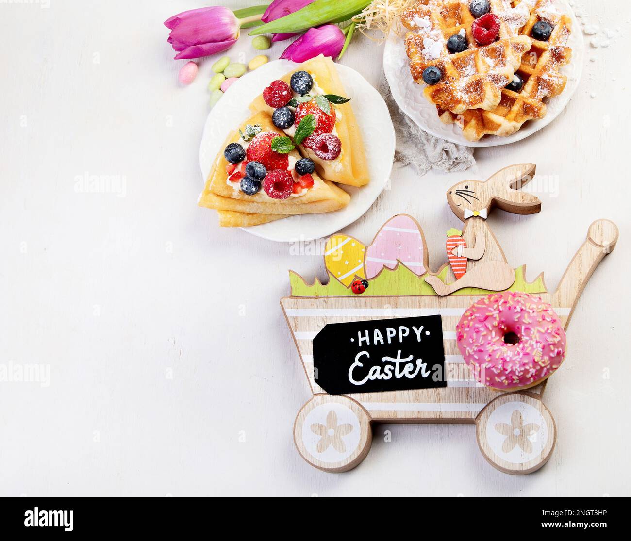 Easter sweet dessert table. Pancakes, crepes, waffles and donuts with ...