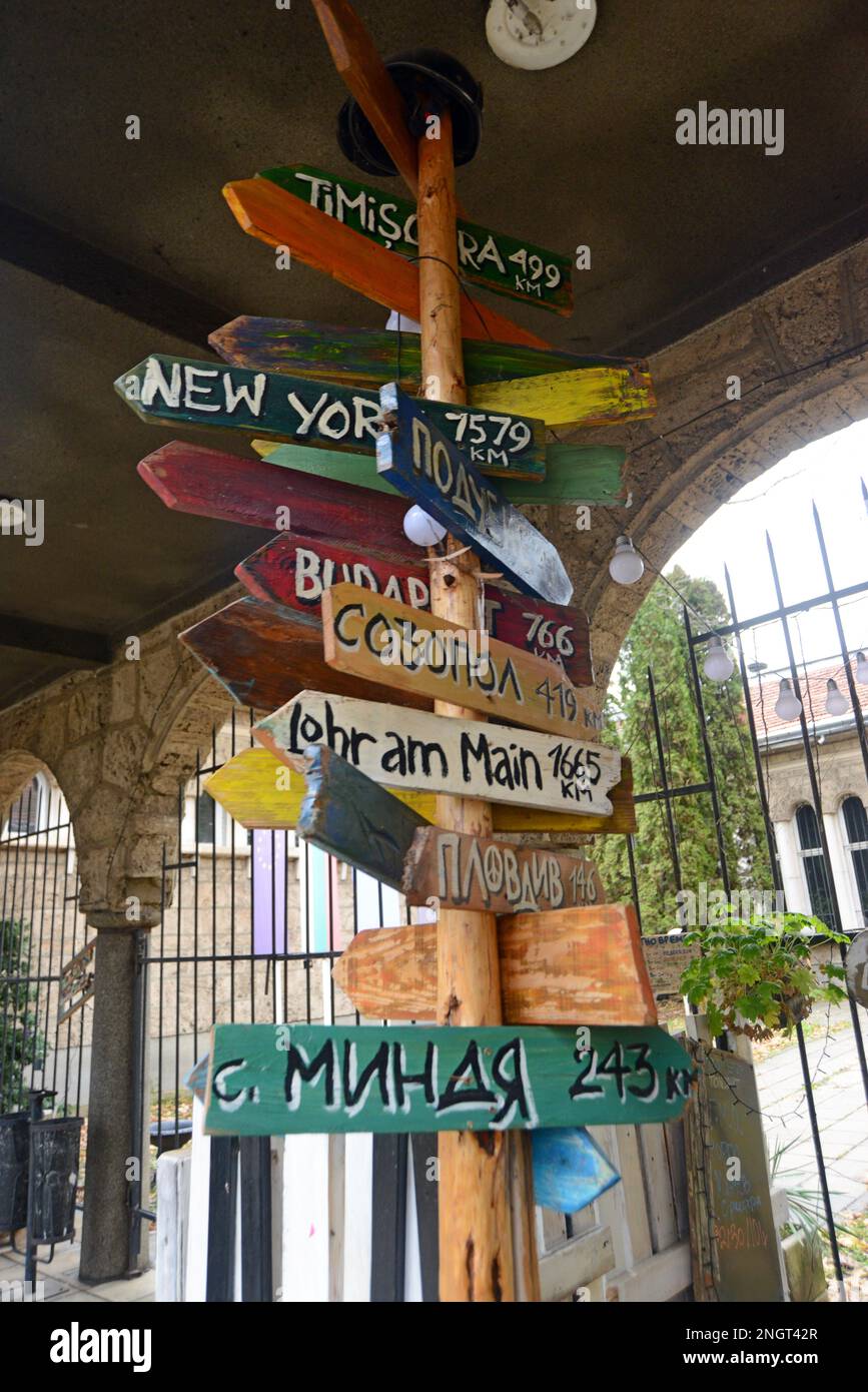 A multi coloured signpost showing distances in miles to cities ...
