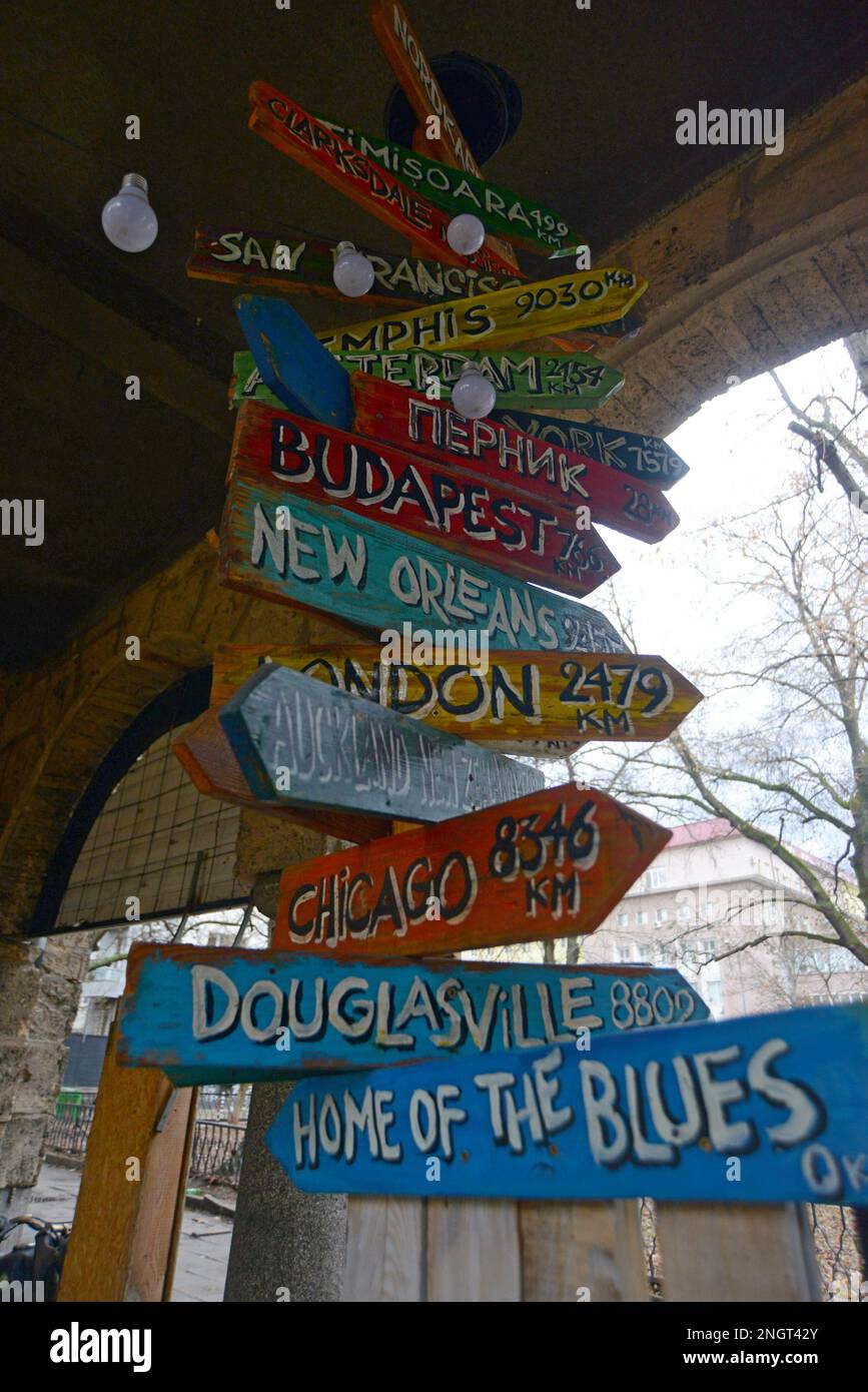 A multi coloured signpost showing distances in miles to cities ...