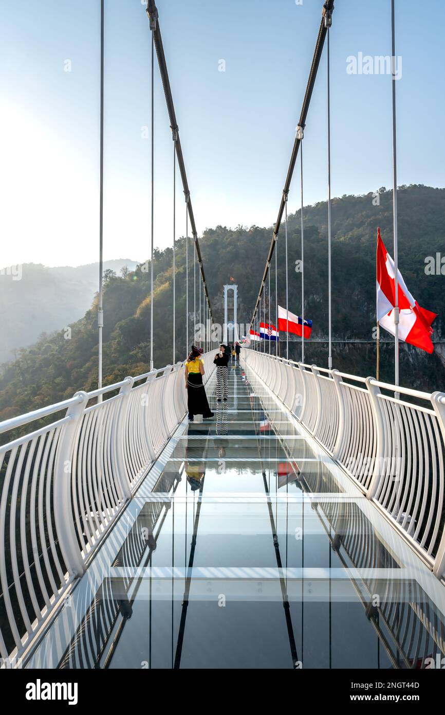A female tourist enjoys walking on Bach Long Glass Bridge. This is the ...