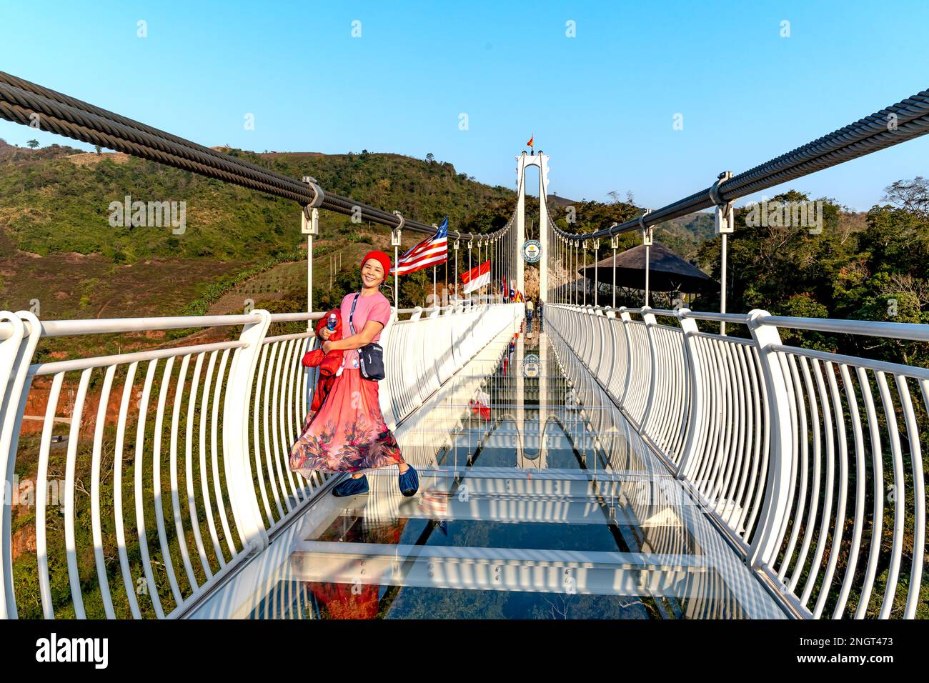 A female tourist enjoys walking on Bach Long Glass Bridge. This is the ...
