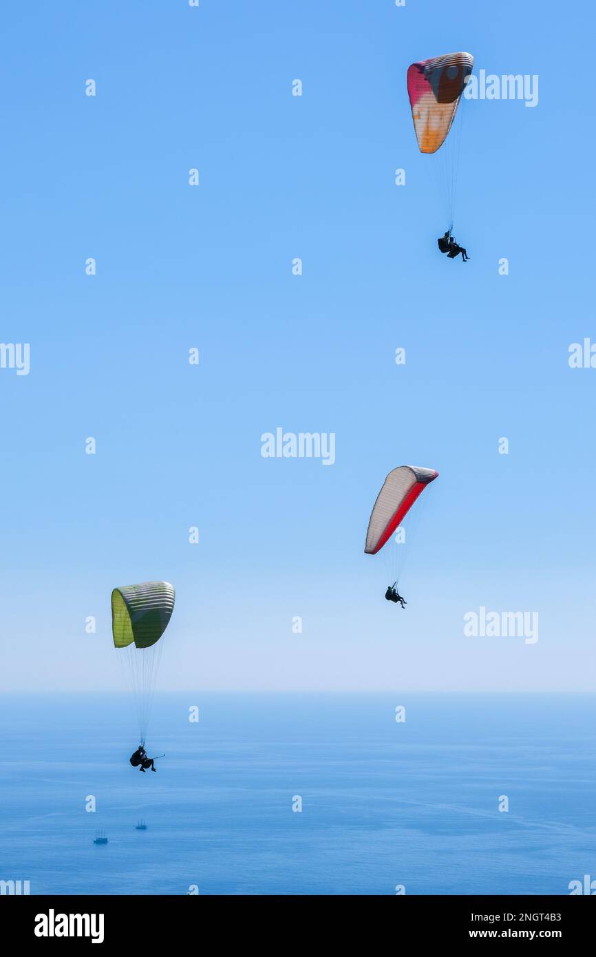 Paragliding in the sky. Paraglider tandem flying over the sea with blue ...