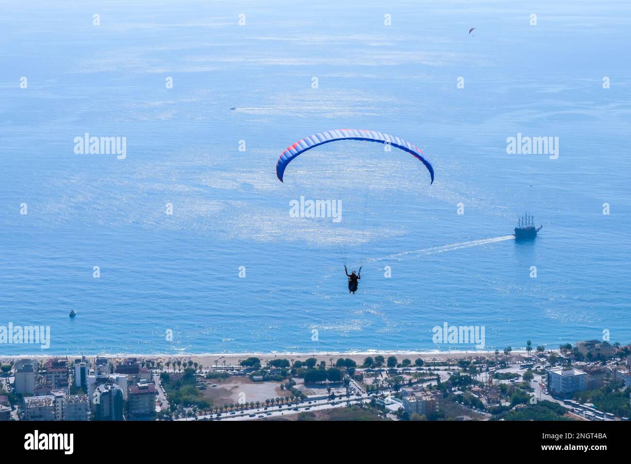 Paragliding in the sky. Paraglider tandem flying over the sea with blue ...
