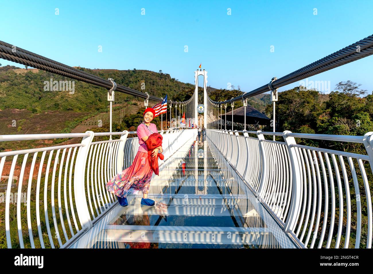 A female tourist enjoys walking on Bach Long Glass Bridge. This is the ...