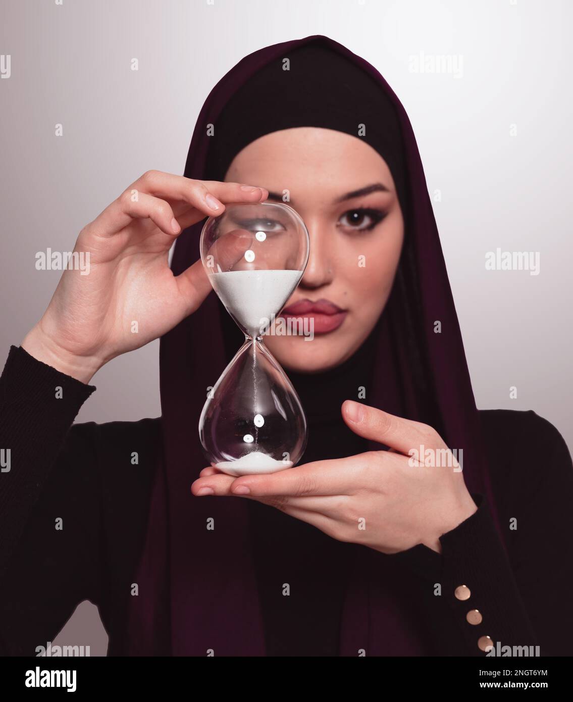 Beautiful arab businesswoman wearing hijab and holding sand clock. Time ...