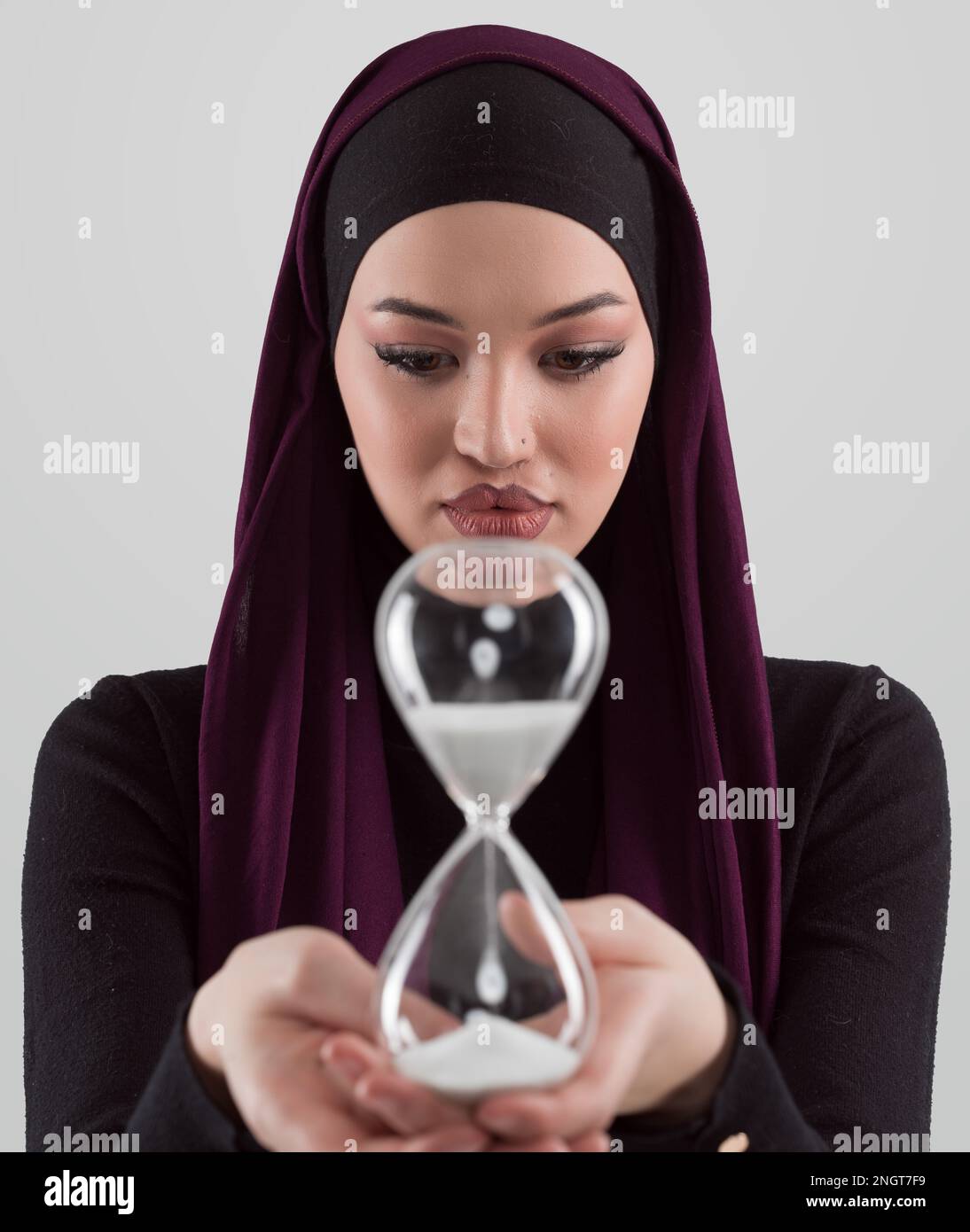 Beautiful arab businesswoman wearing hijab and holding sand clock. Time ...