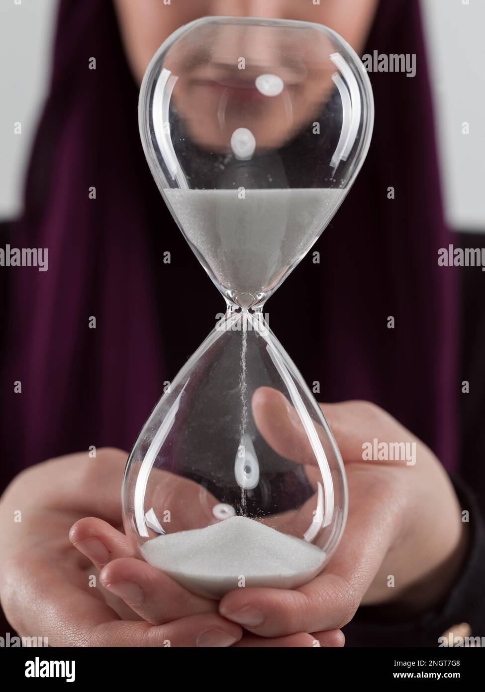 Beautiful arab businesswoman wearing hijab and holding sand clock. Time ...