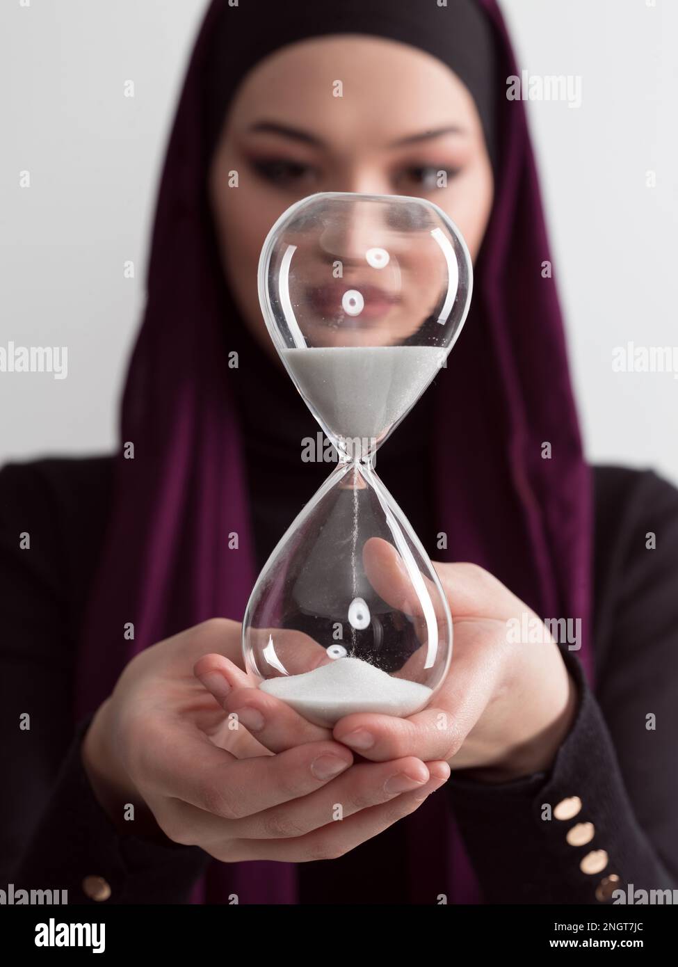 Beautiful arab businesswoman wearing hijab and holding sand clock. Time ...