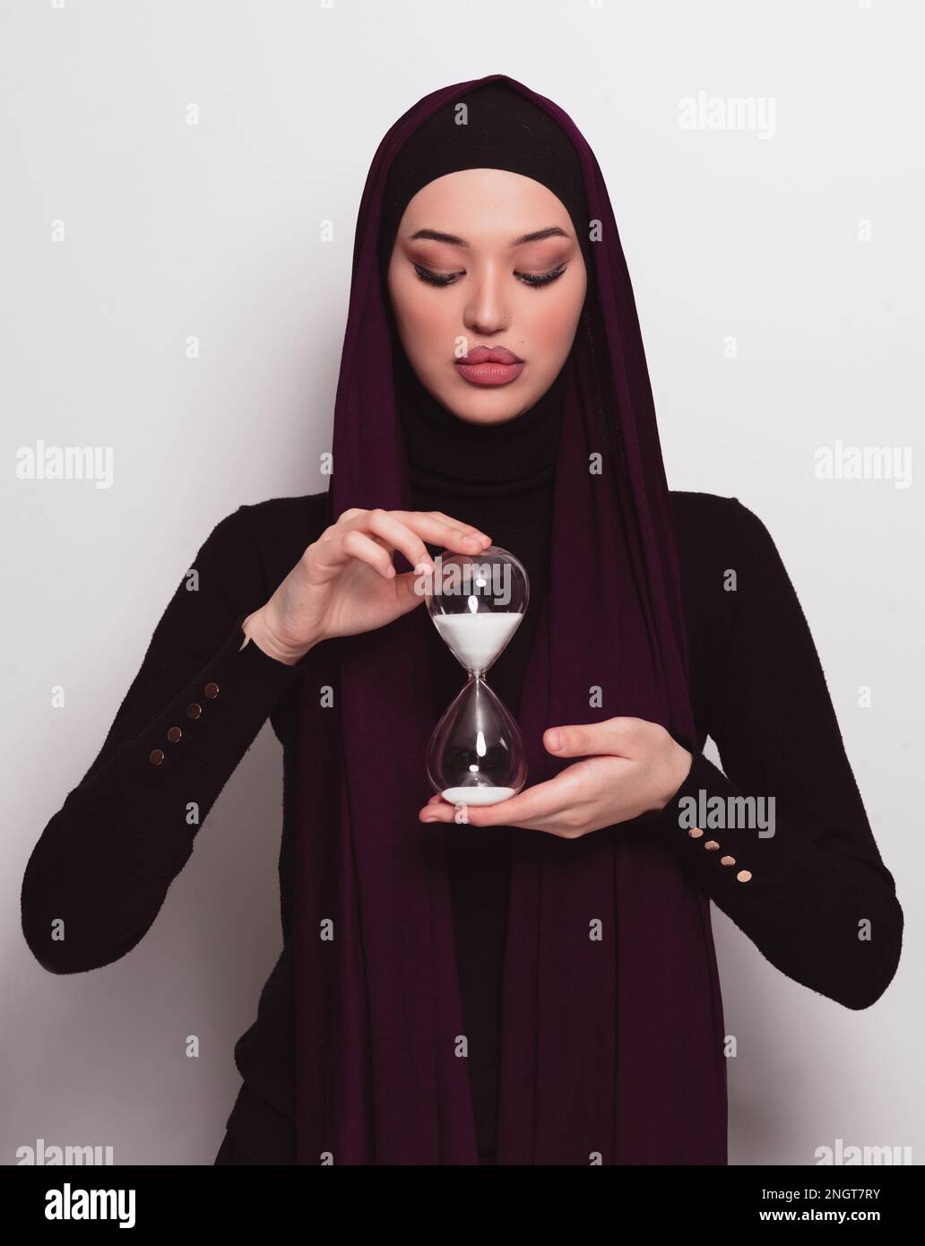 Beautiful arab businesswoman wearing hijab and holding sand clock. Time ...