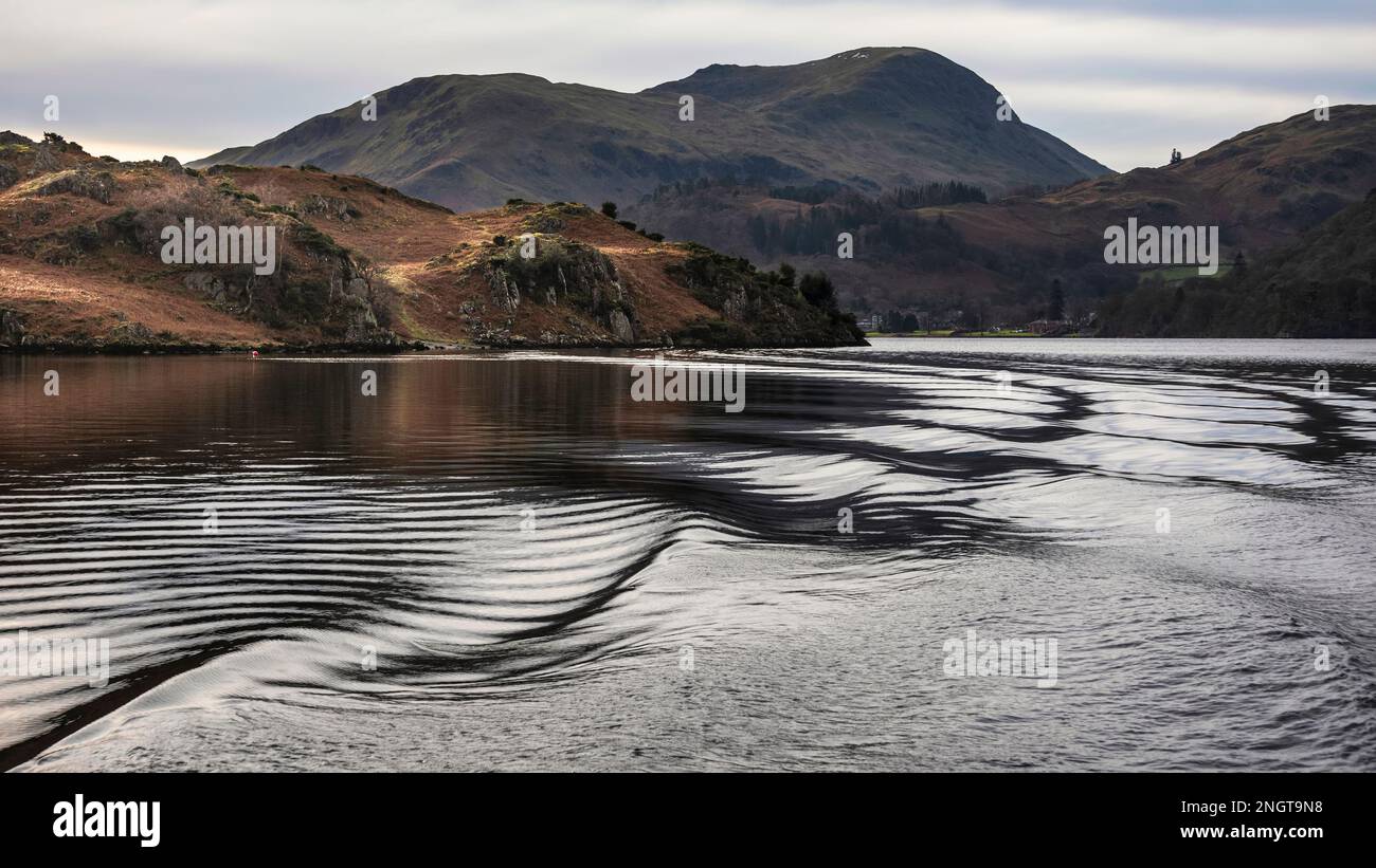 Beautiful Winter landscape image viewed from boat on Ullswater in Lake ...