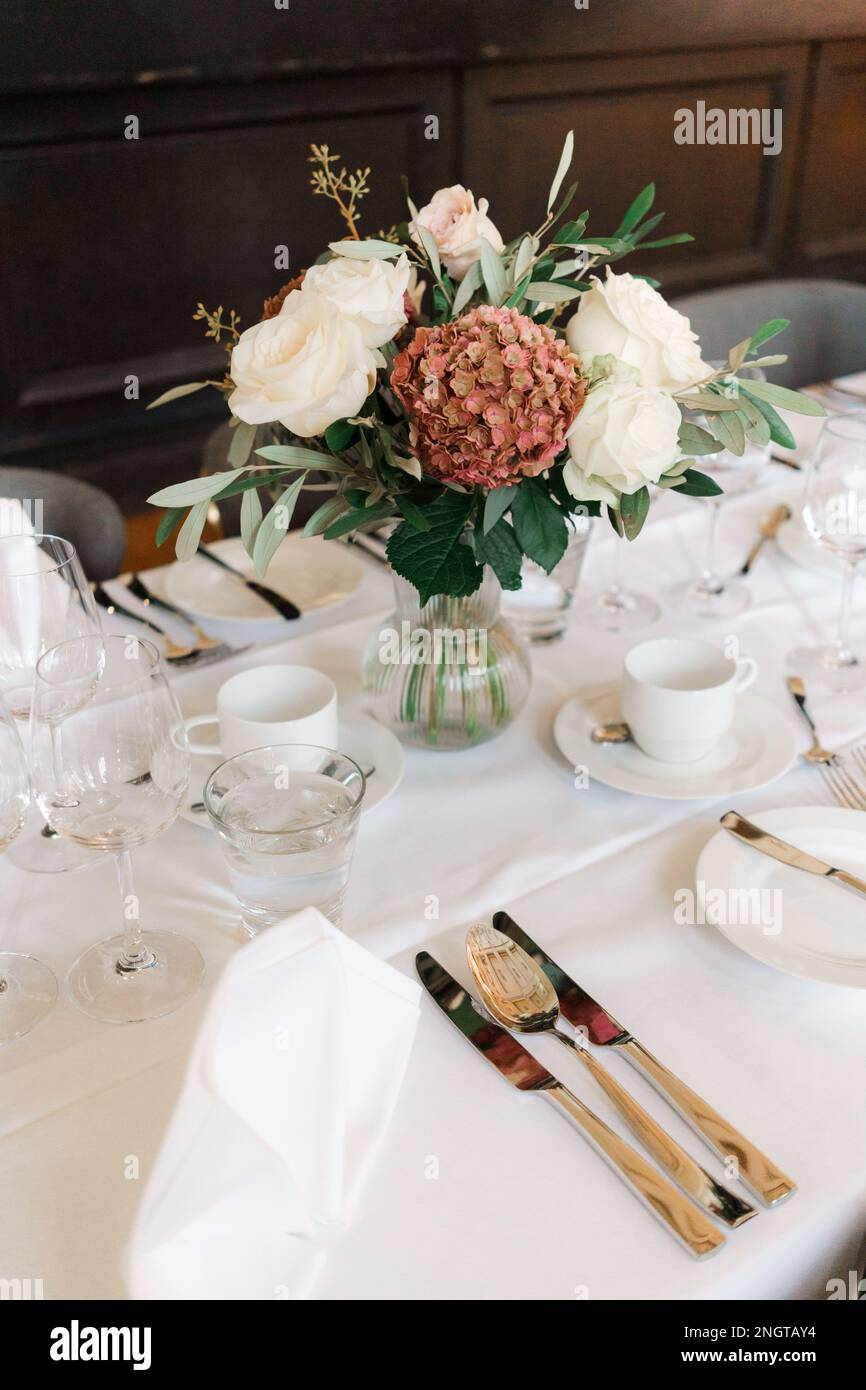 wedding table setting with flowers in vase and cutlery. Bouquet of ...