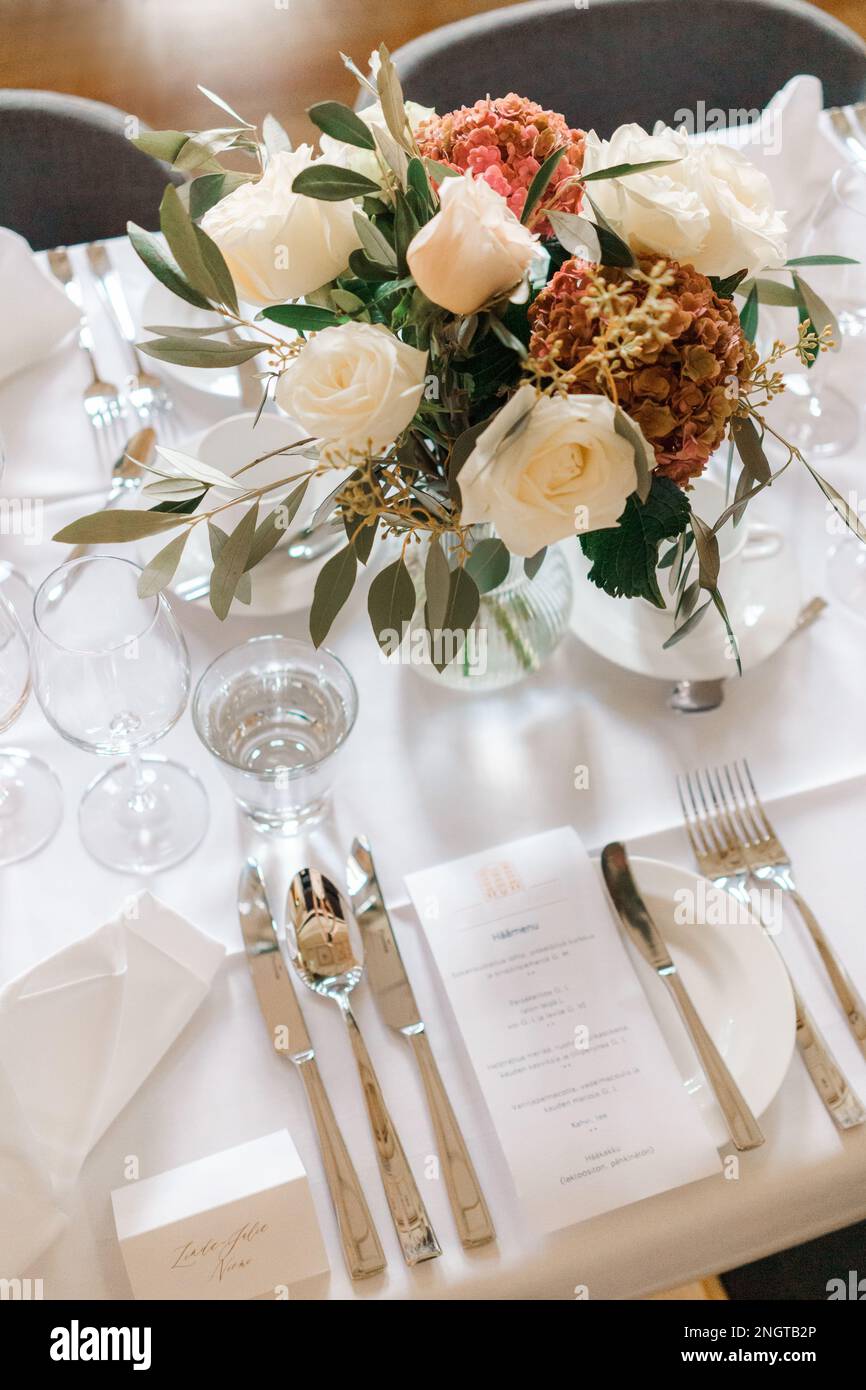 wedding table setting with flowers in vase and cutlery. Bouquet of ...