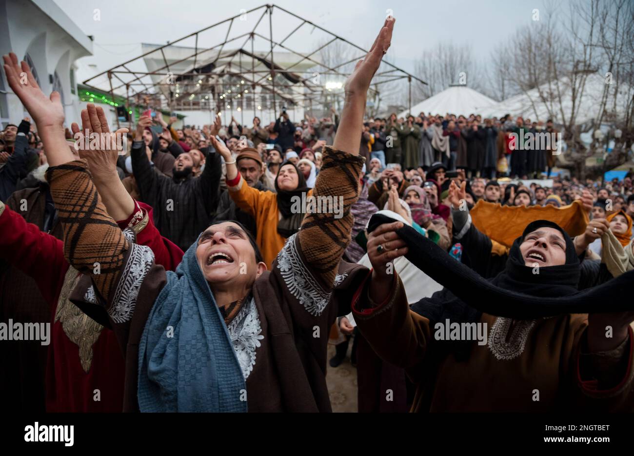 Muslim devotees raise their hands while praying as the head priest ...