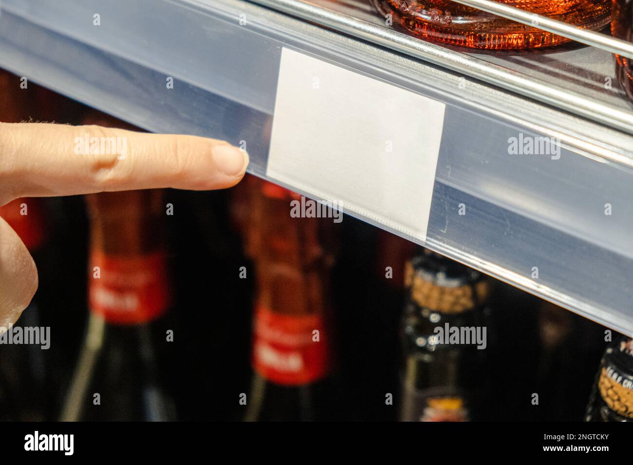 a female hand points to a price tag in a supermarket Stock Photo - Alamy