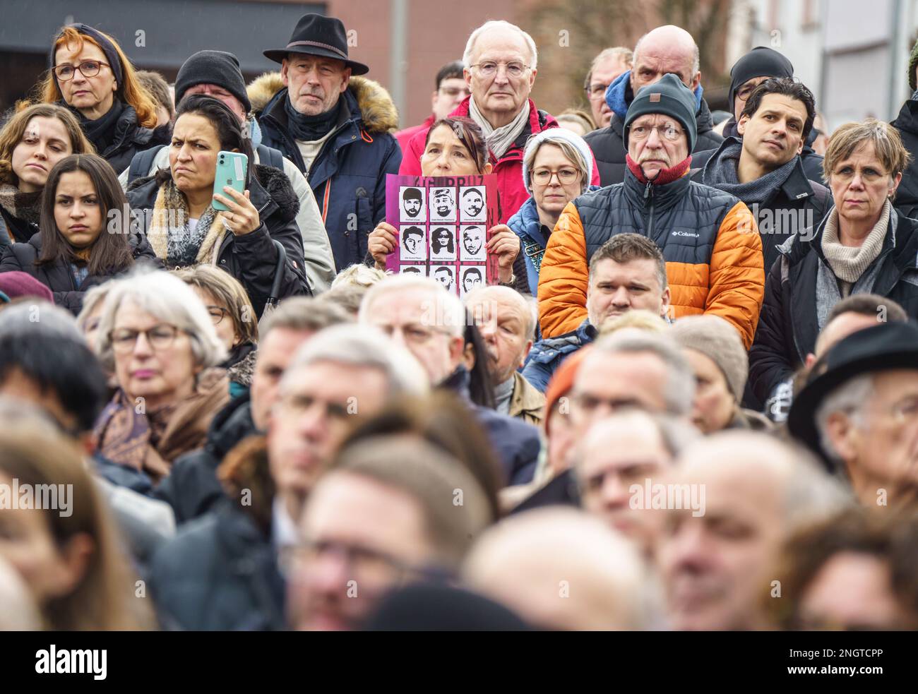Hanau, Germany. 19th Feb, 2023. A woman (M) holds a poster with ...