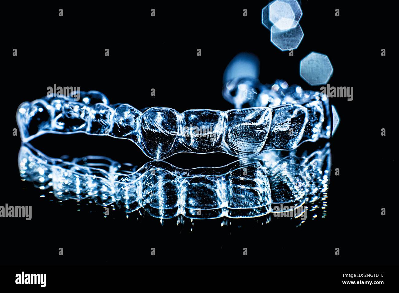 Invisible aligner teeth retainers on a black background Stock Photo - Alamy