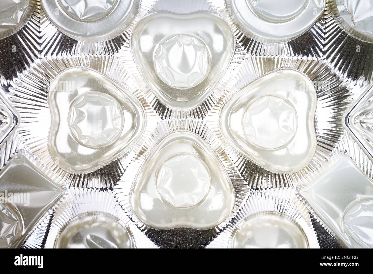 Close up shot of empty box of chocolates. Shiny gold plastic texture of ...