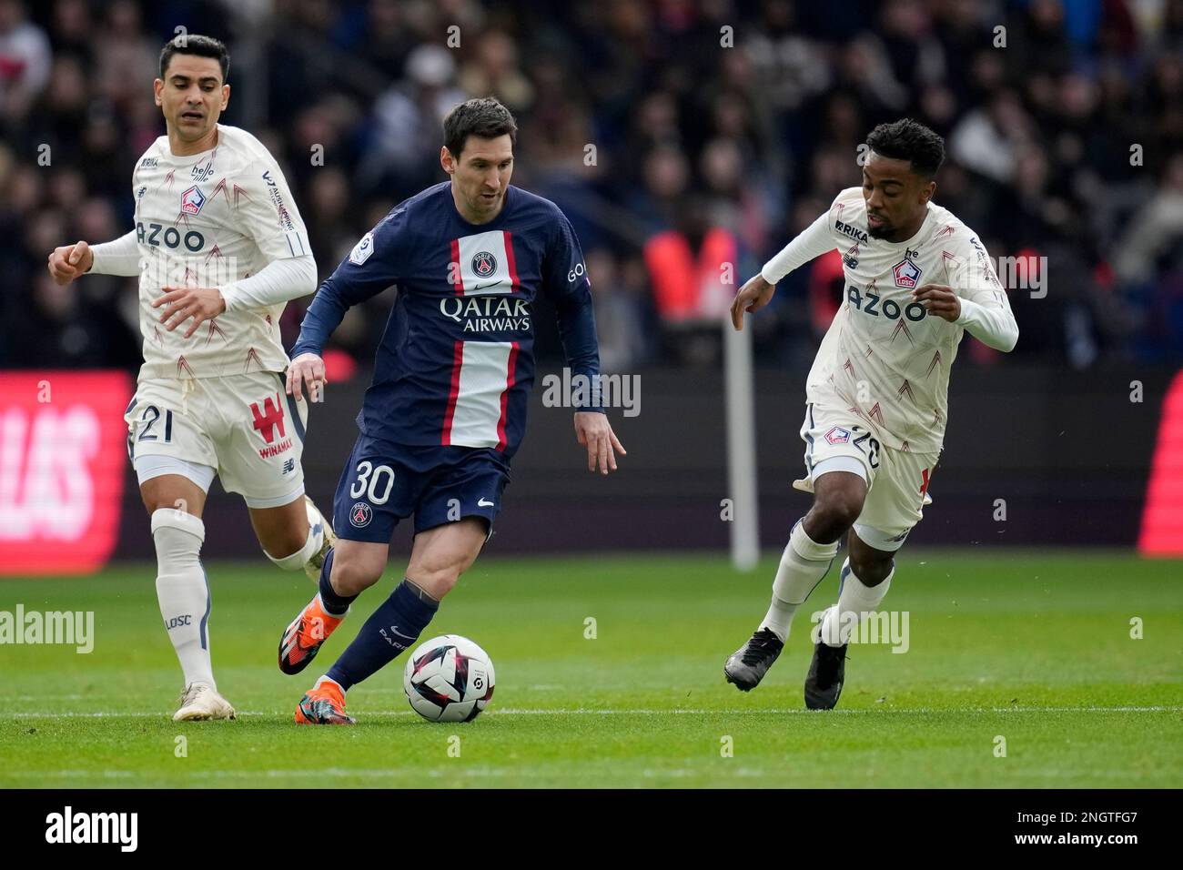 PSG's Lionel Messi, centre, dribbles past Lille's Benjamin Andre, left ...