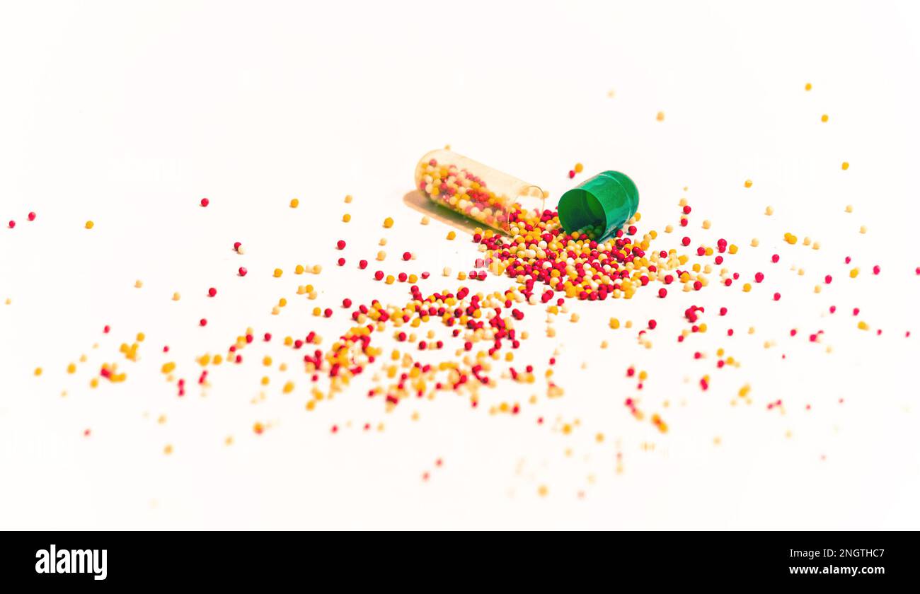 open pill with scattered small remedy, isolated Stock Photo - Alamy