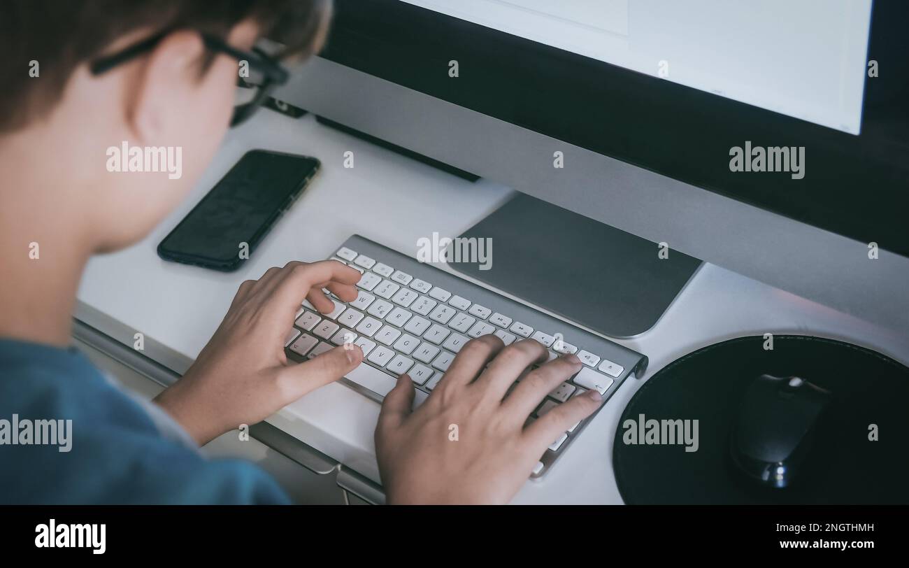 Student doing homeworks typing on computer keyboard. Teen using ...