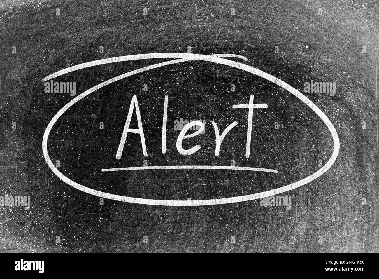 White chalk hand writing in word alert and circle shape on blackboard ...