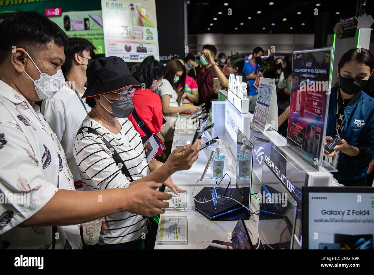 Visitors inspect mobile phones during the Thailand Mobile Expo 2023 in ...