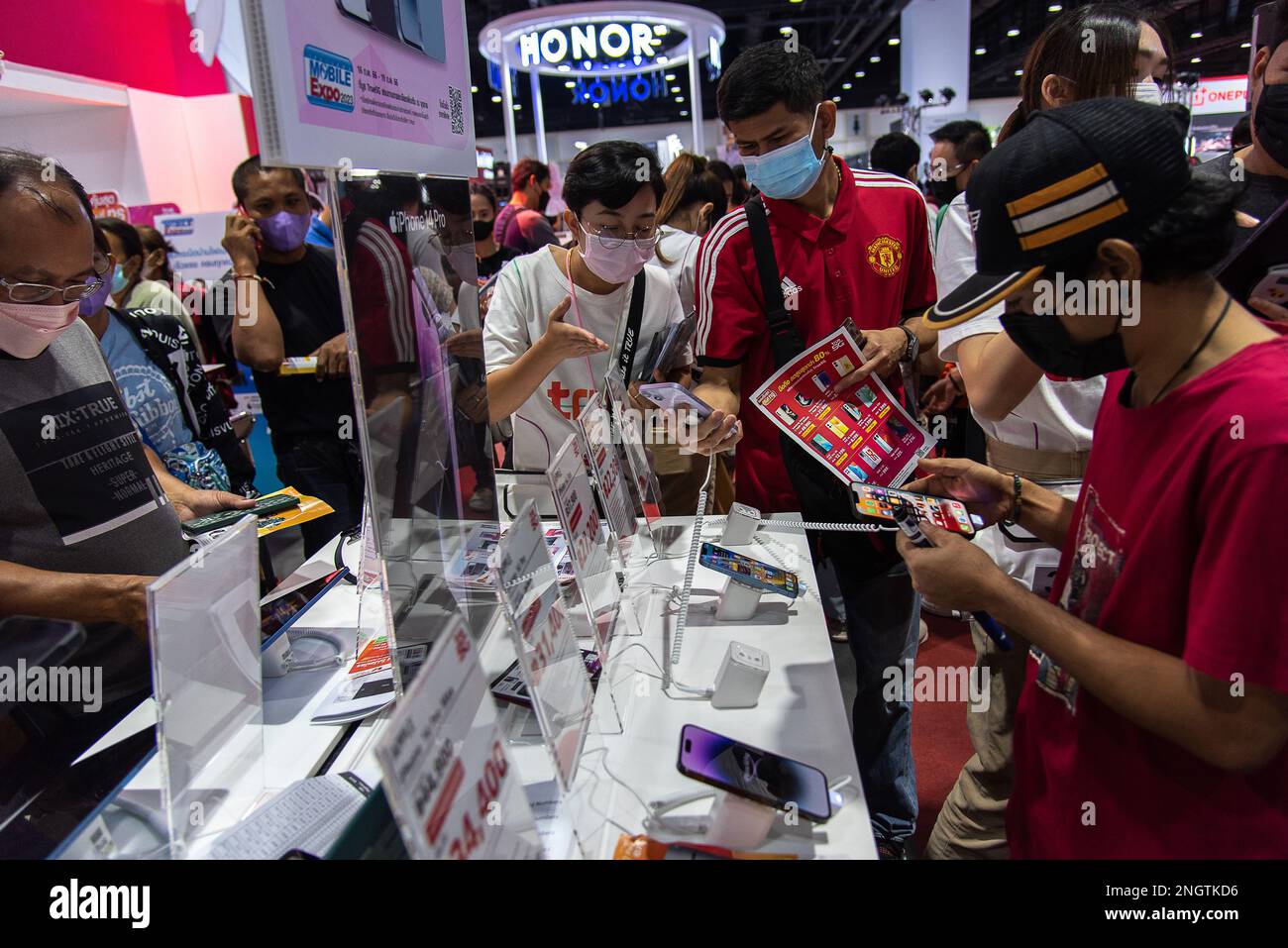 Visitors inspect mobile phones during the Thailand Mobile Expo 2023 in ...