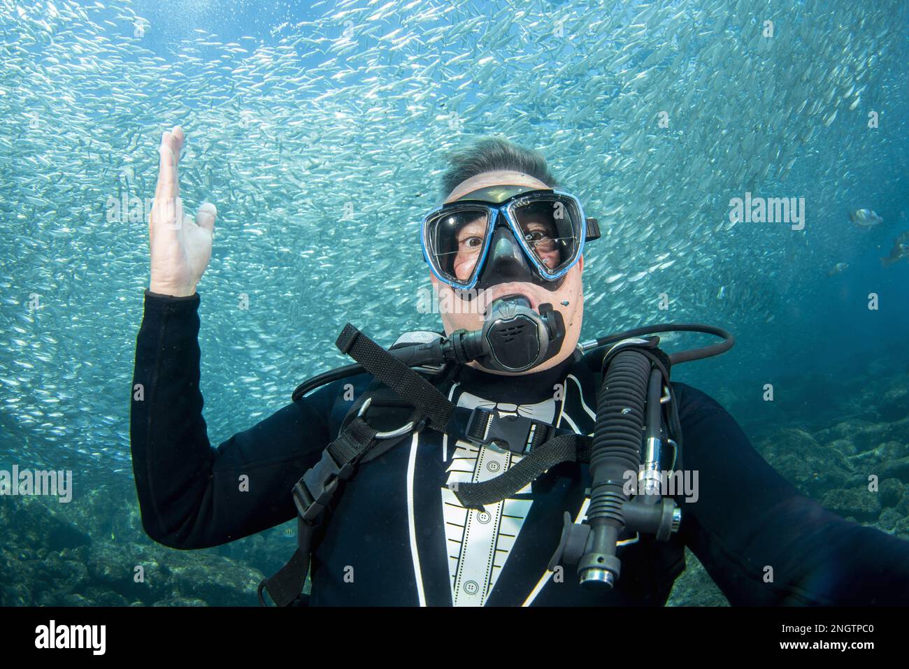 Scuba diver underwater selfie in the deep blue ocean and backlight sun ...