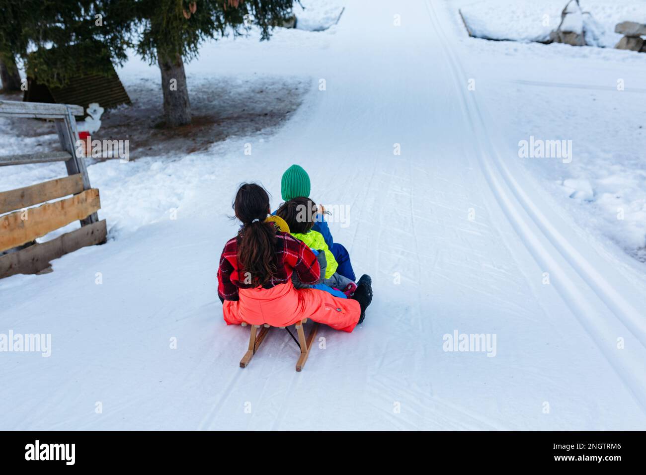 group of children in bright winter clothes riding one wooden sled going ...