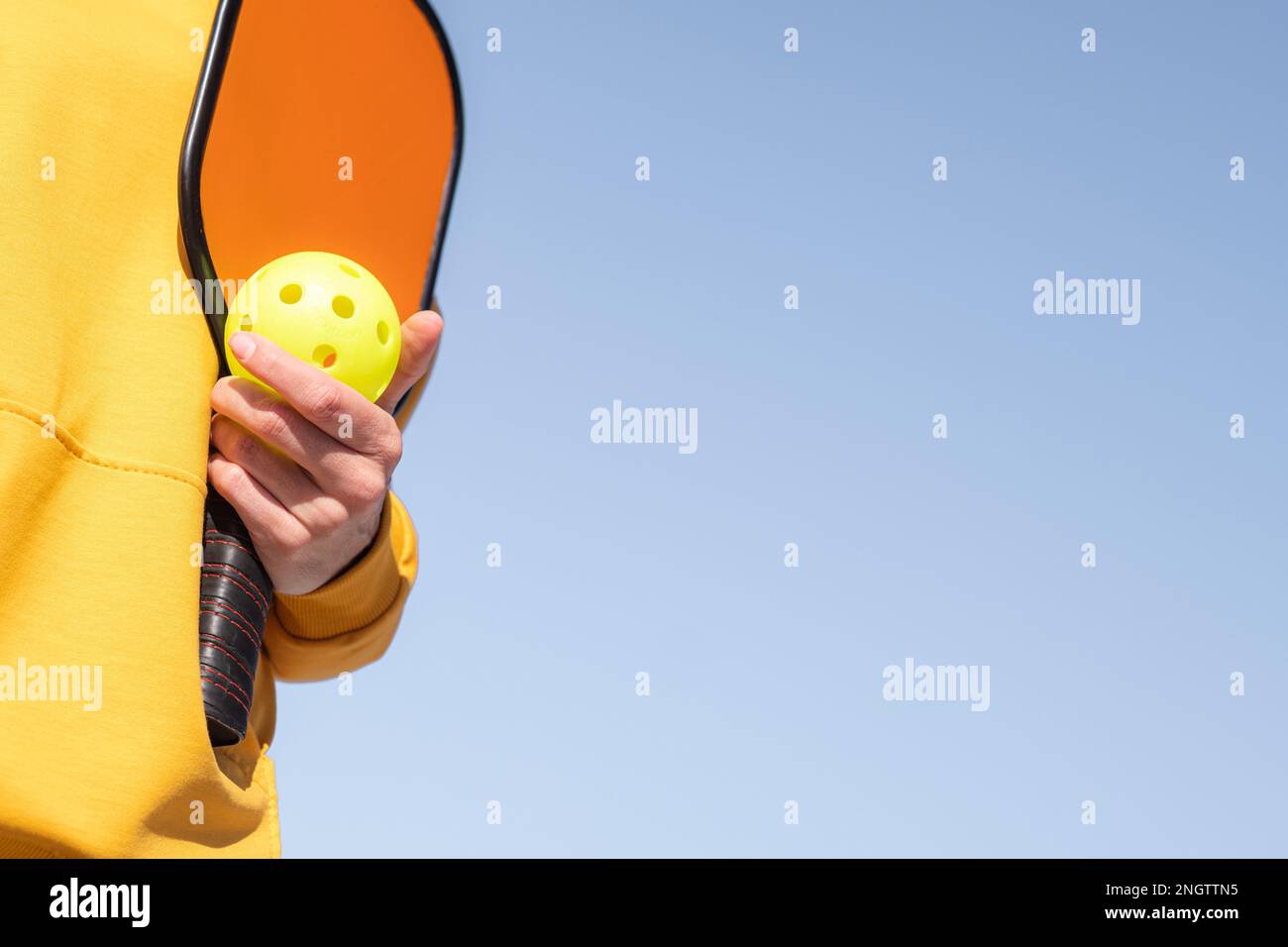 Pickleball paddle and yellow ball close up in hands woman player ...