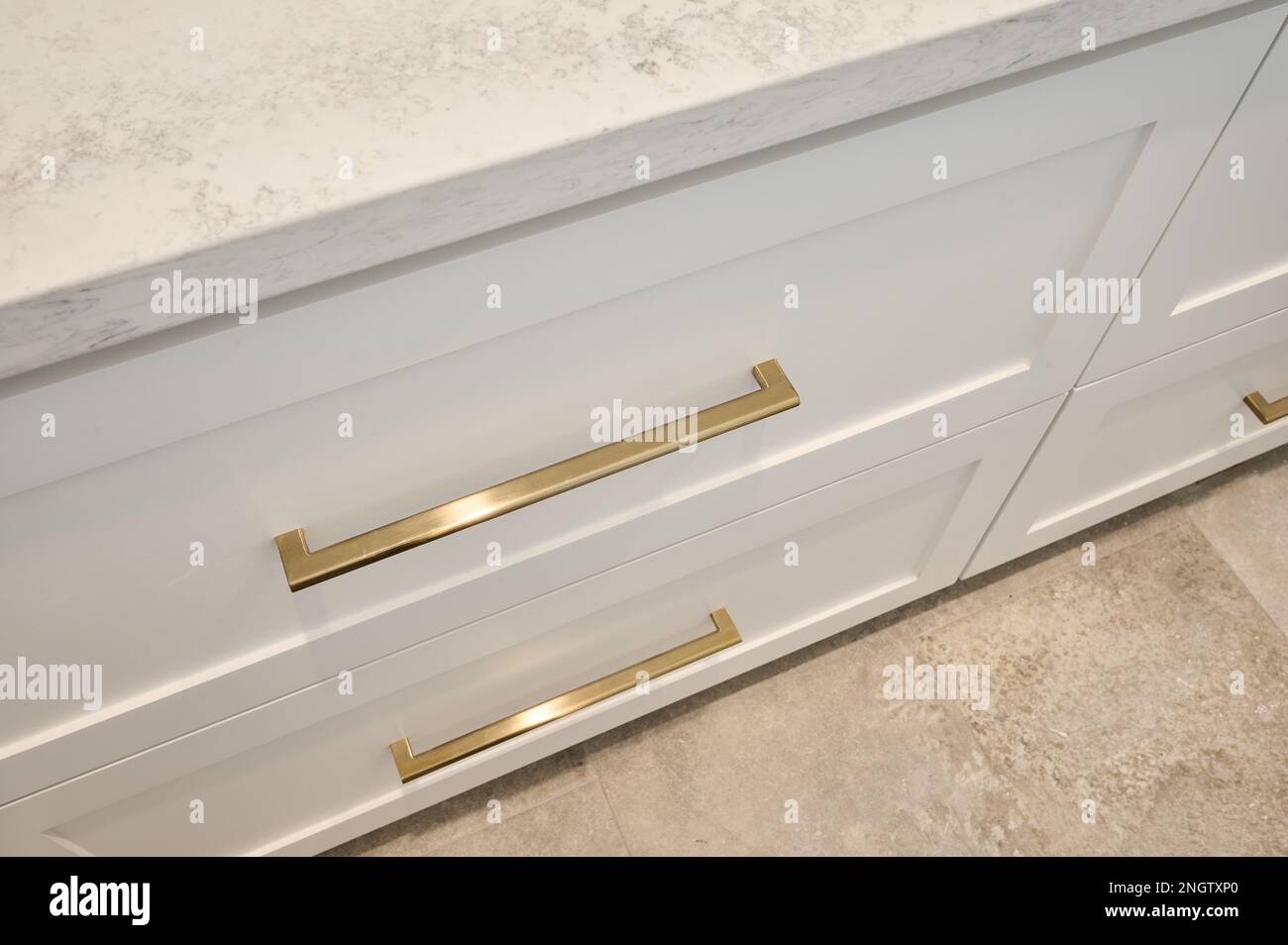 closeup angled view of cabinet drawers with gold hardware and stone ...