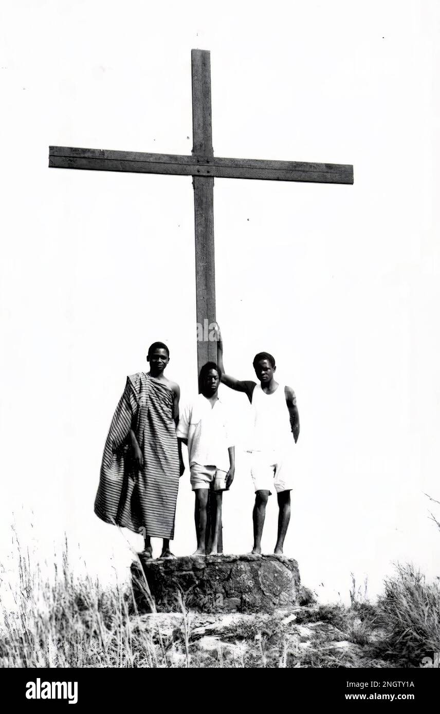 People standing next to the large cross at the top of Mount Gemi near ...