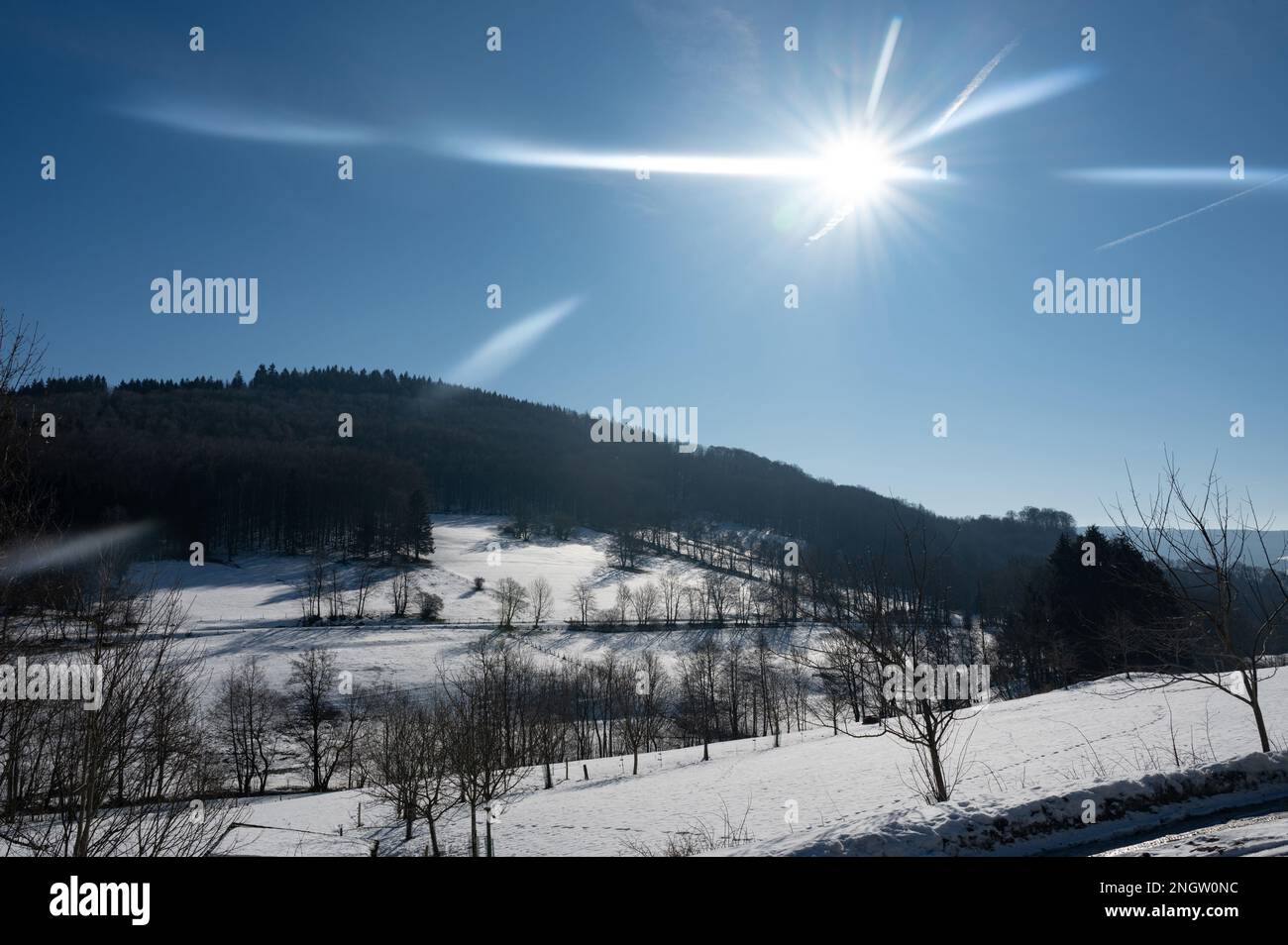Landscape in winter with a lot of snow, bright sun and blue sky in the ...