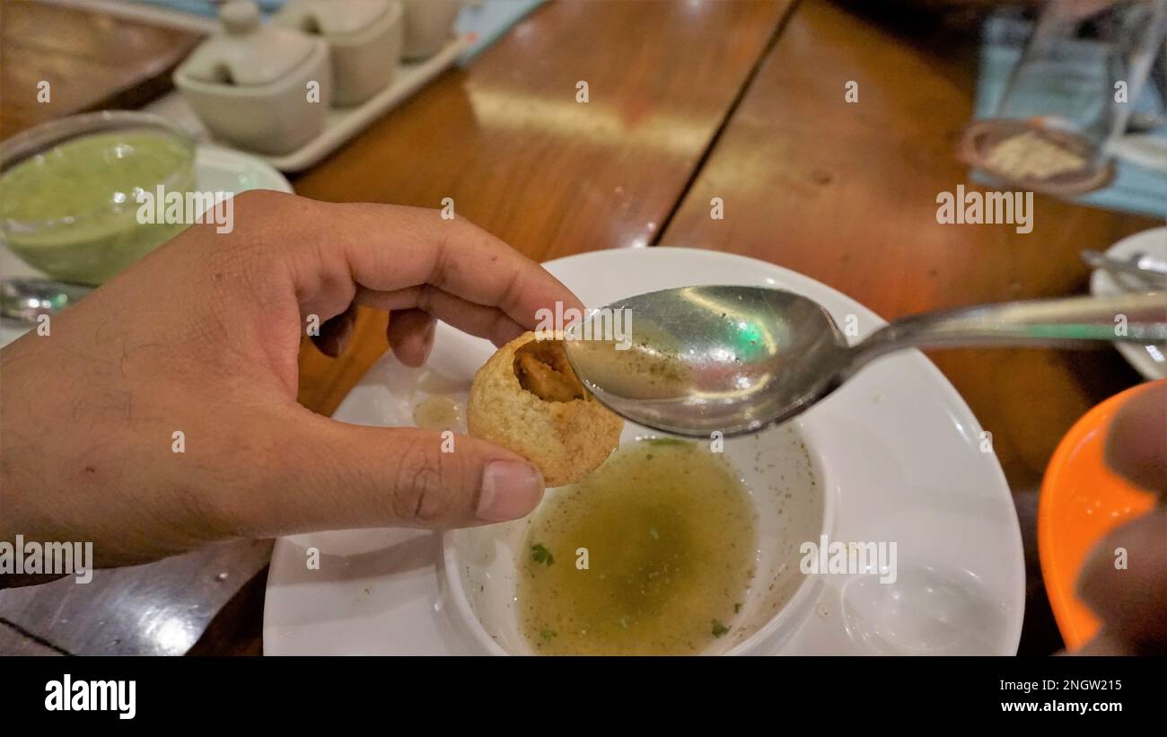 Indian man holding Panipuri or Golgappa or Puchkas with potato masala ...