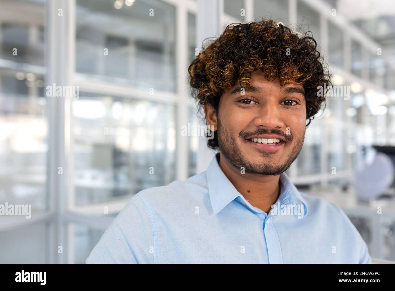 Young smiling indian programmer close up smiling and looking at camera ...