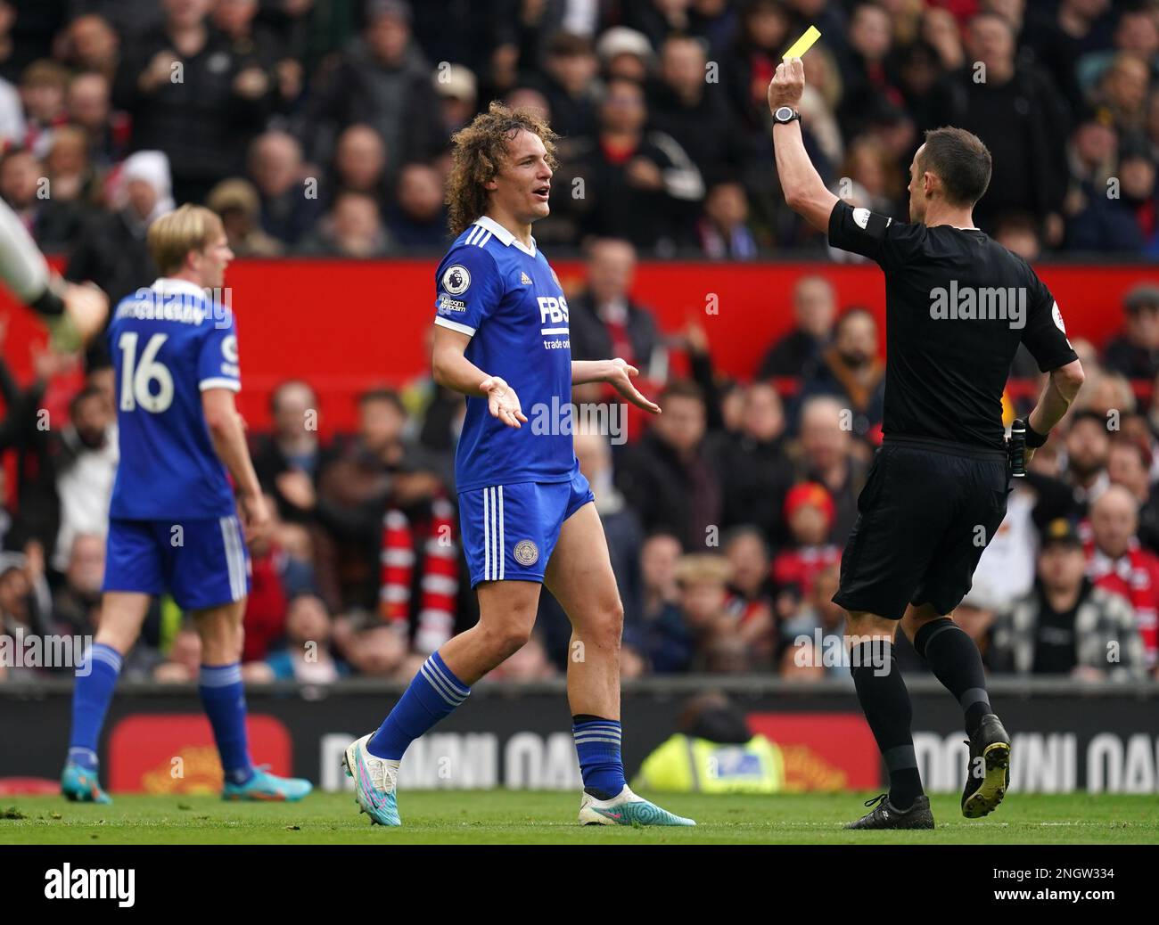 Referee Stuart Attwell (right) shows a yellow card to Leicester City's ...