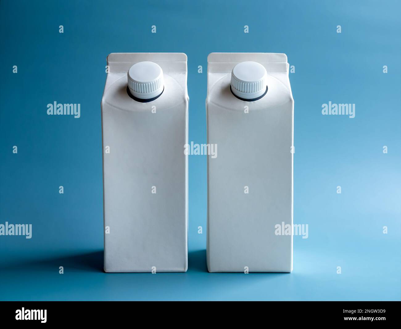 Mockup of two white milk boxes 1 liter with screw cap standing isolated ...