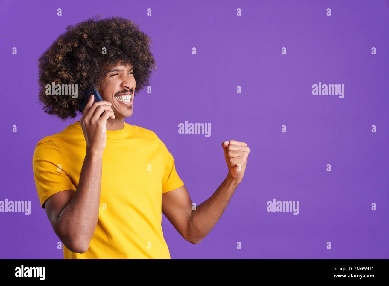 Happy african man celebrating while taking to the mobile Stock Photo ...