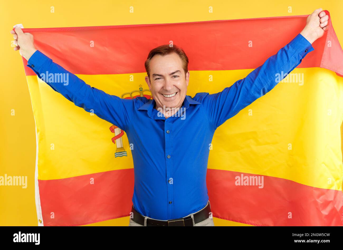 Smiling mature man raising a spanish flag Stock Photo - Alamy
