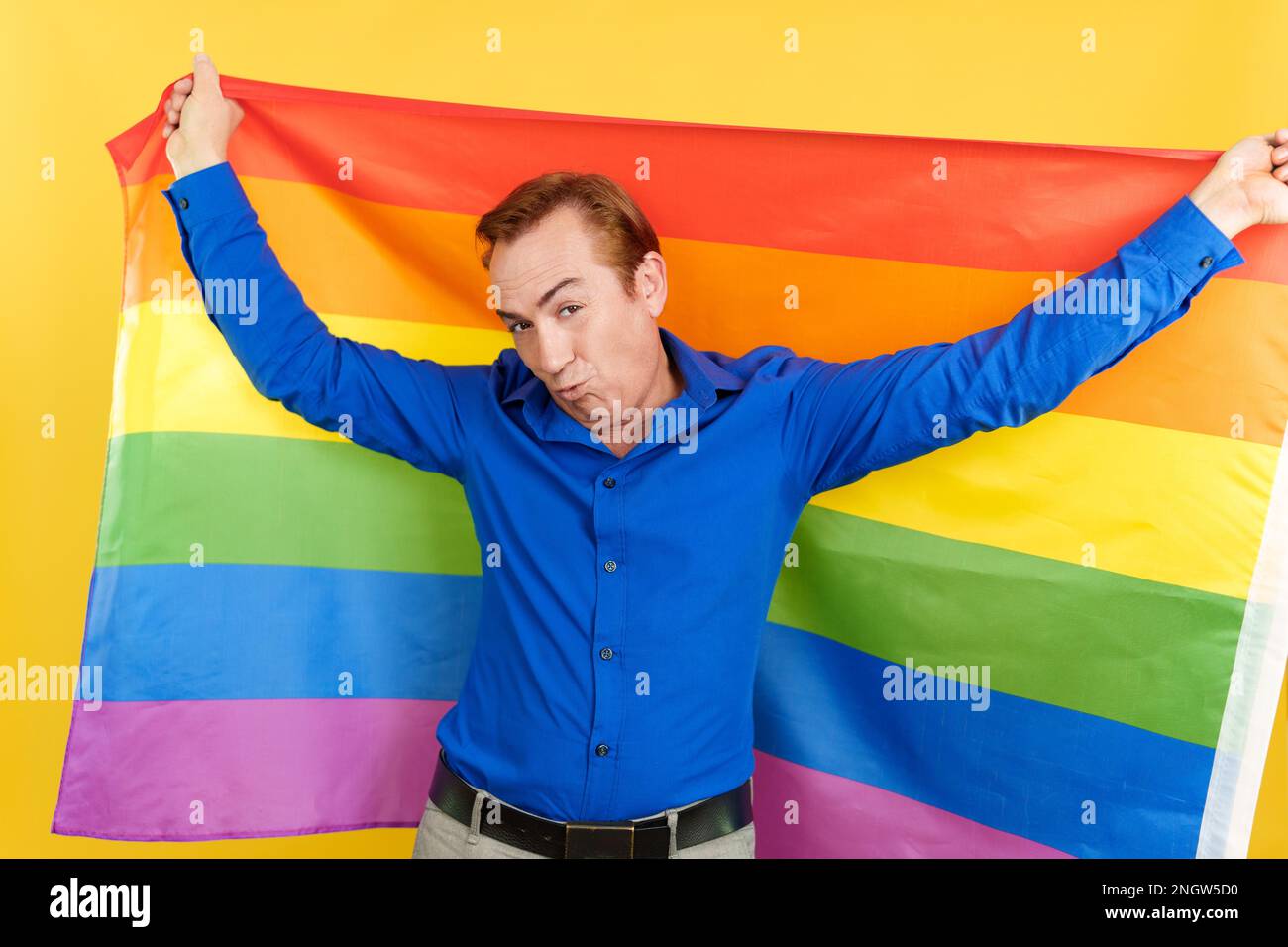 Mature man blowing a kiss raising a lgbt rainbow flag Stock Photo - Alamy