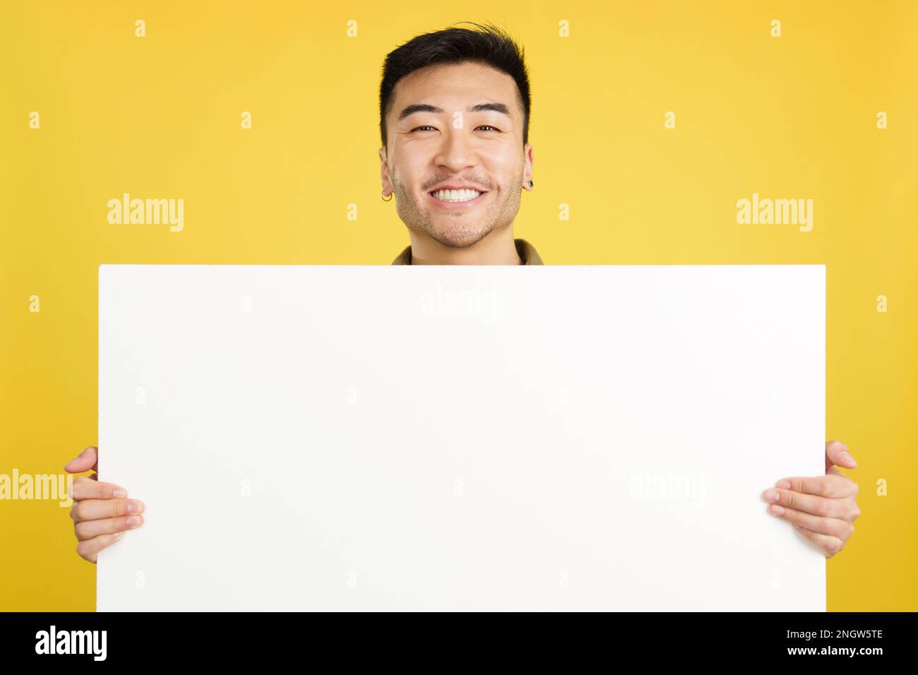 Happy chinese man smiling and holding a blank panel Stock Photo - Alamy