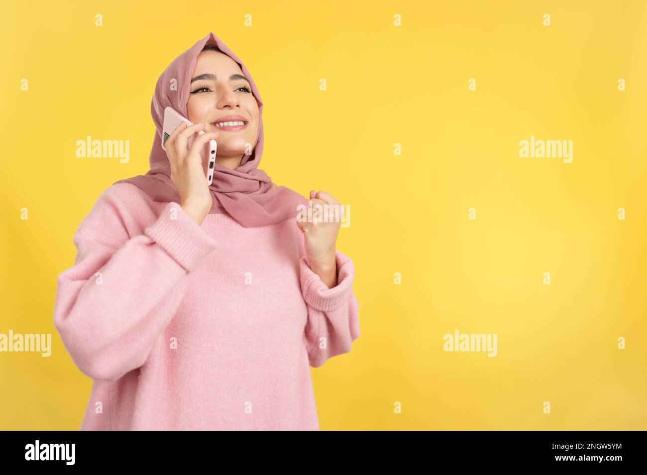 Happy muslim woman celebrating while talking to the mobile Stock Photo ...