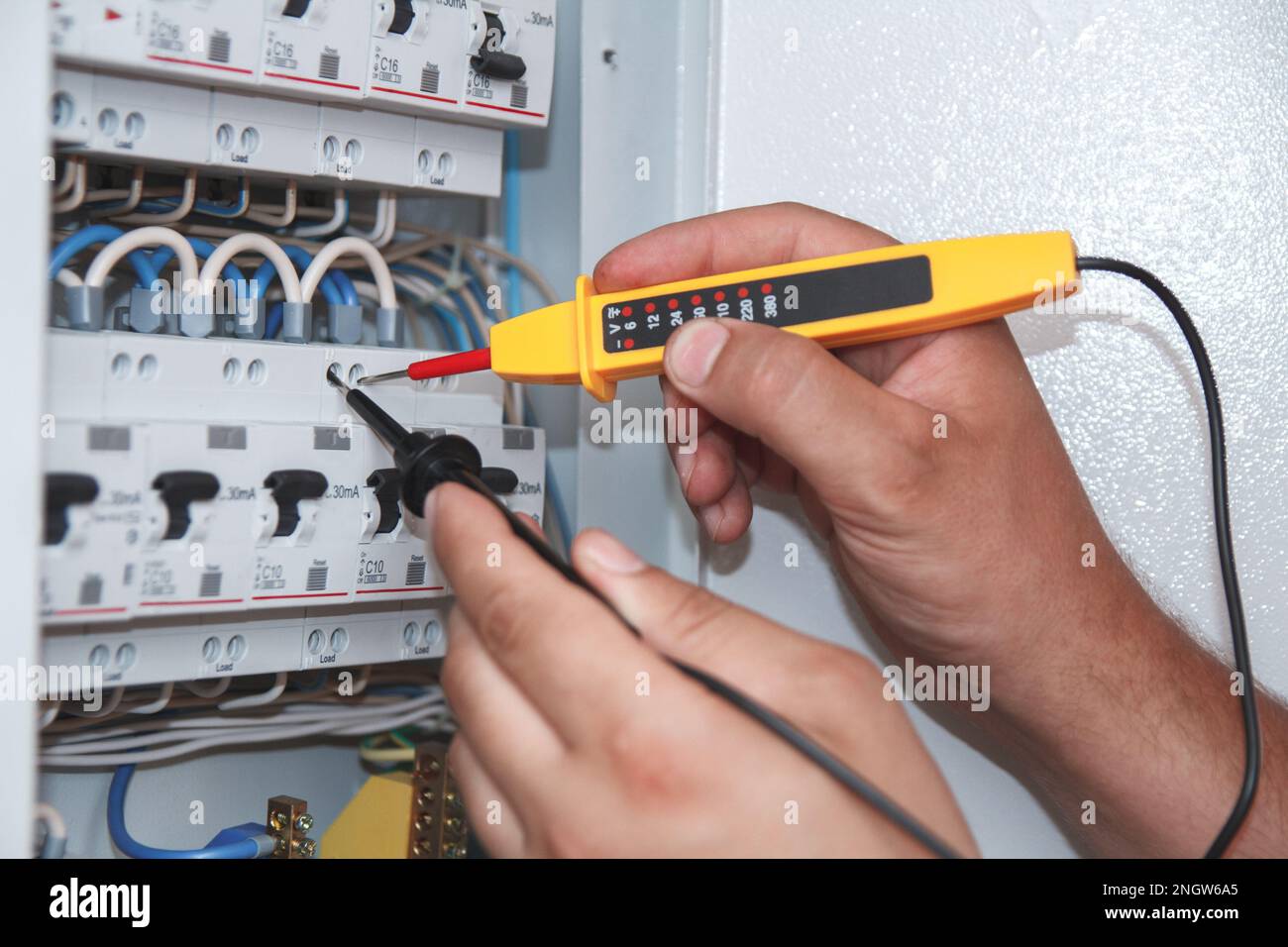 Electrician with multimeter probe at an electrical switchgear ca Stock ...