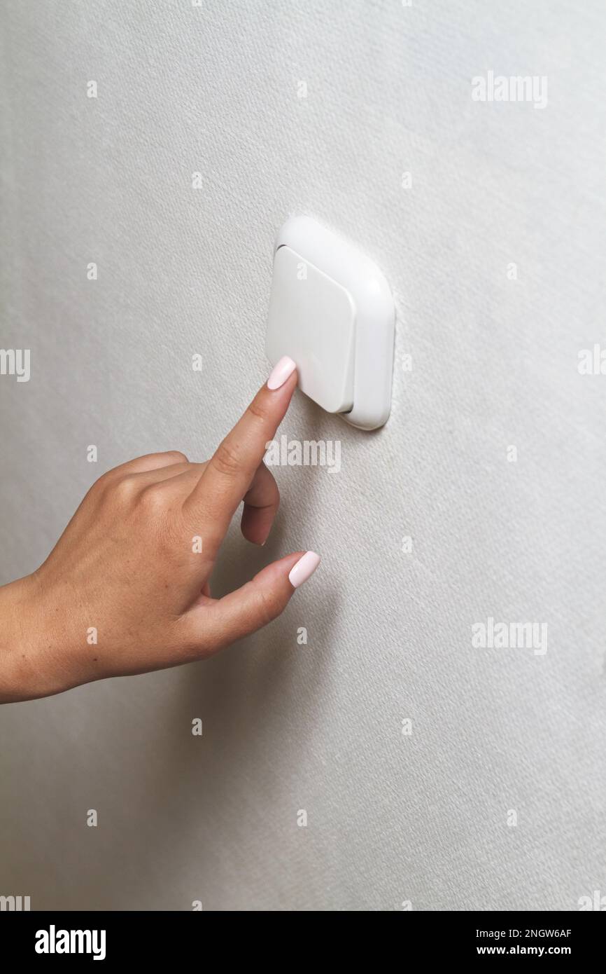 Female hand turns off the light indoors. Electrical energy savin Stock ...