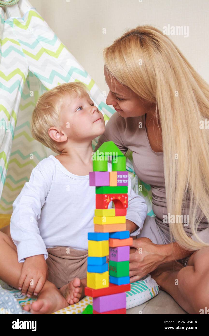Mom and son build a tower together from constructor Stock Photo - Alamy